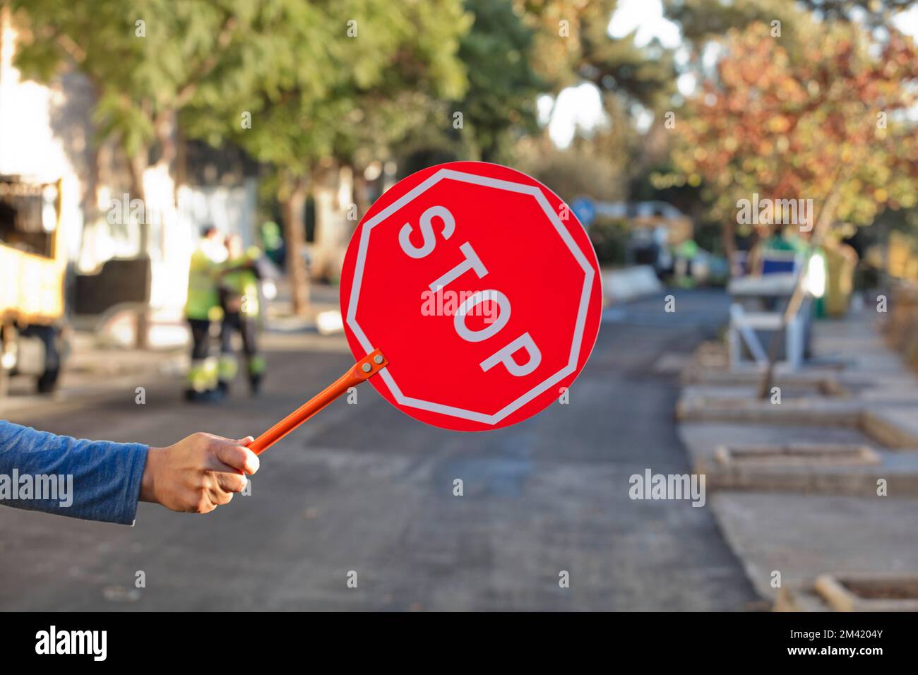 stop sign on urban road in the hands of an operator, street in the ...