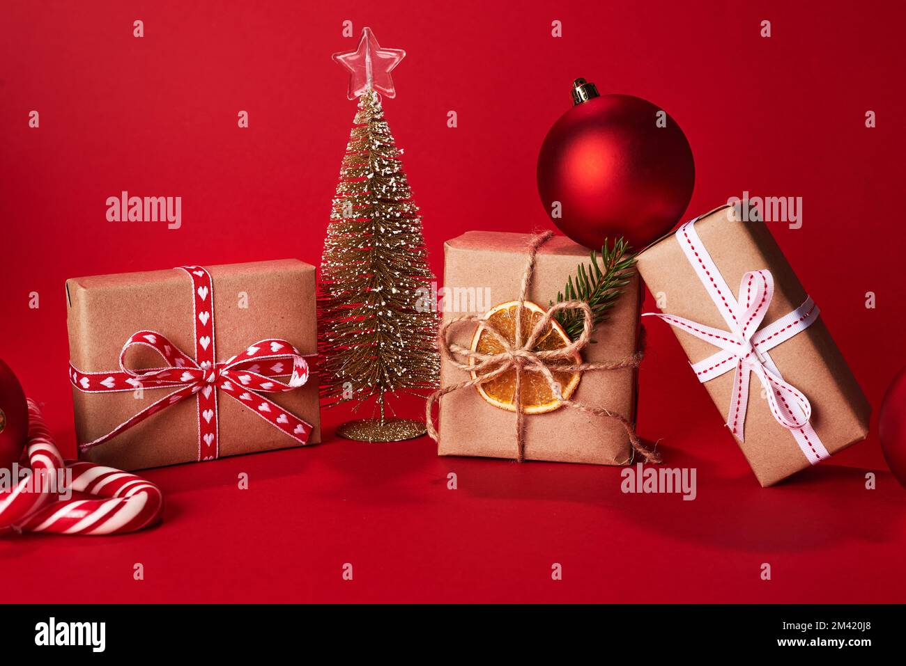 christmas gifts near small christmas tree on red background. Greeting ...