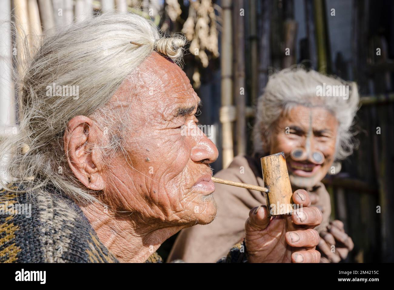 Portrait of an old Apatani man wearing the traditional hairstyle with ...
