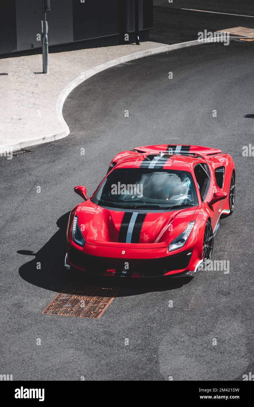A vertical of a red Ferrari with black stripes captured from a top view ...