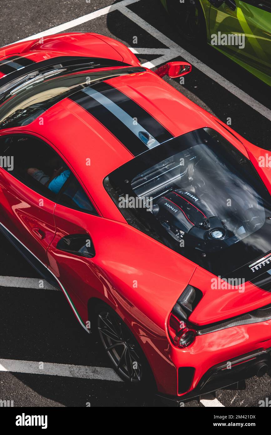 A vertical of a red Ferrari with black stripes captured from a top view ...