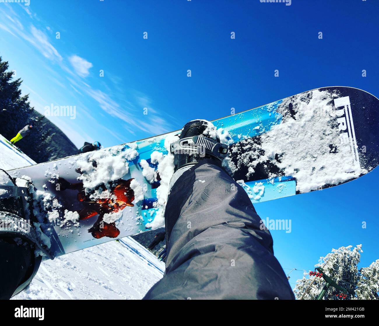 The snowy snowboard on the feet of a person Stock Photo - Alamy
