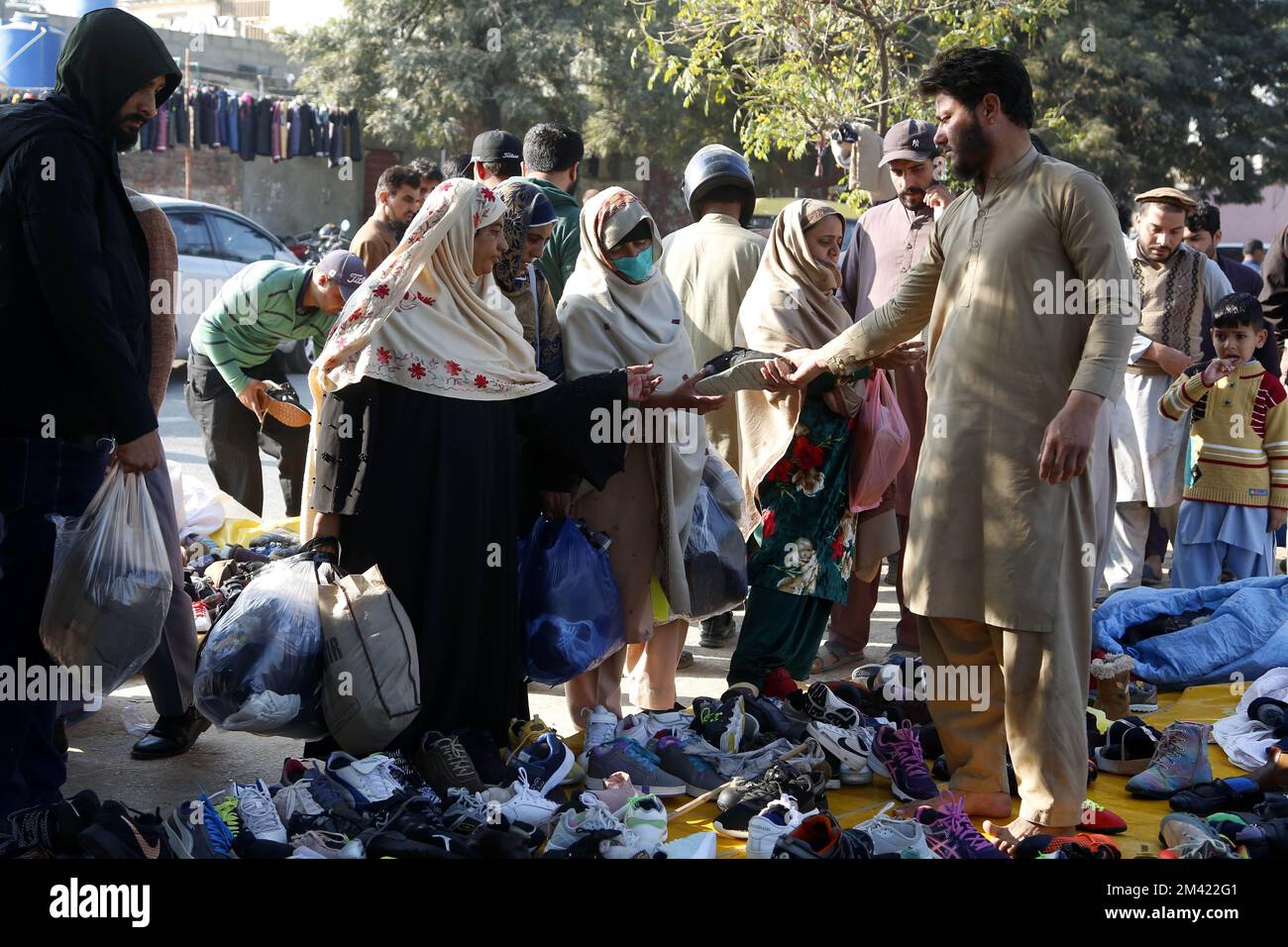 Islamabad, Pakistan. 18th Dec, 2022. People buy shoes at a flea market ...