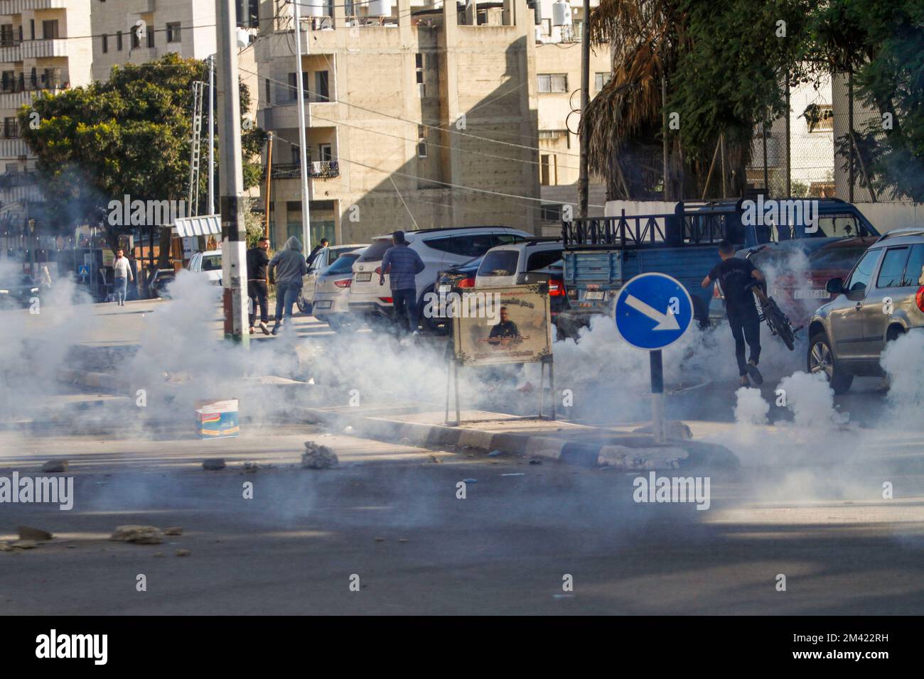 A Palestinian flees to hide from tear gas fired by the Israeli army at ...
