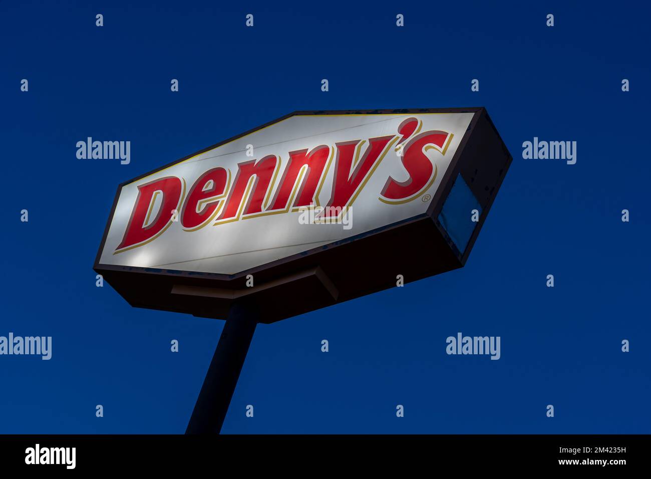 An Illuminated Denny’s pole sign with dark blue sky in the night is ...