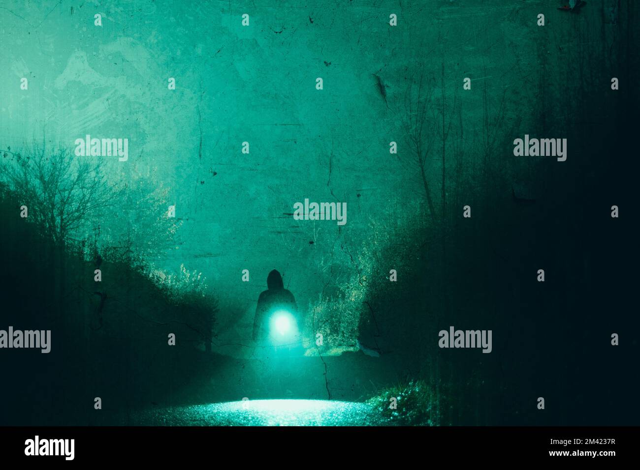 A scary hooded figure carrying a torch, silhouetted along a mysterious ...