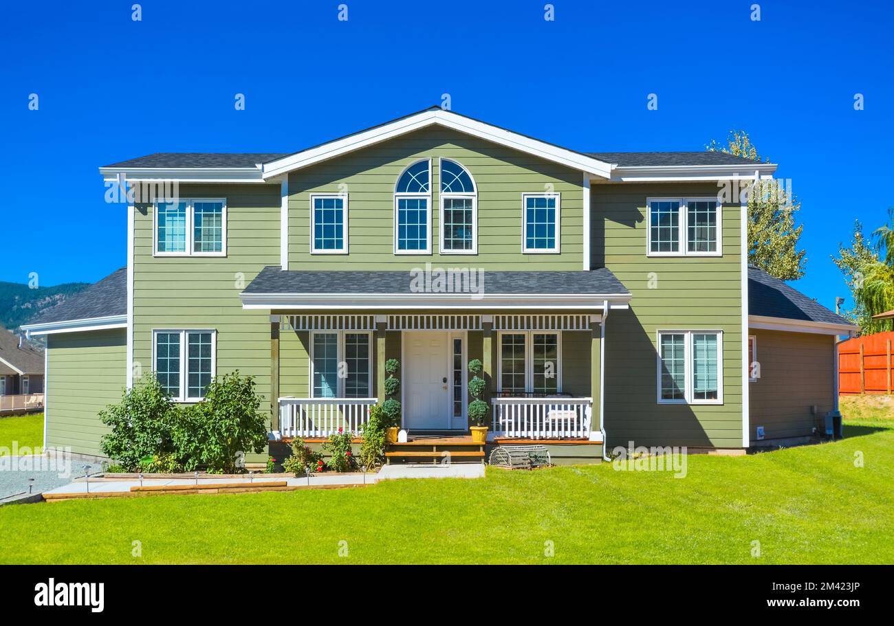 Big family house with pathway to the door in front and blue sky ...