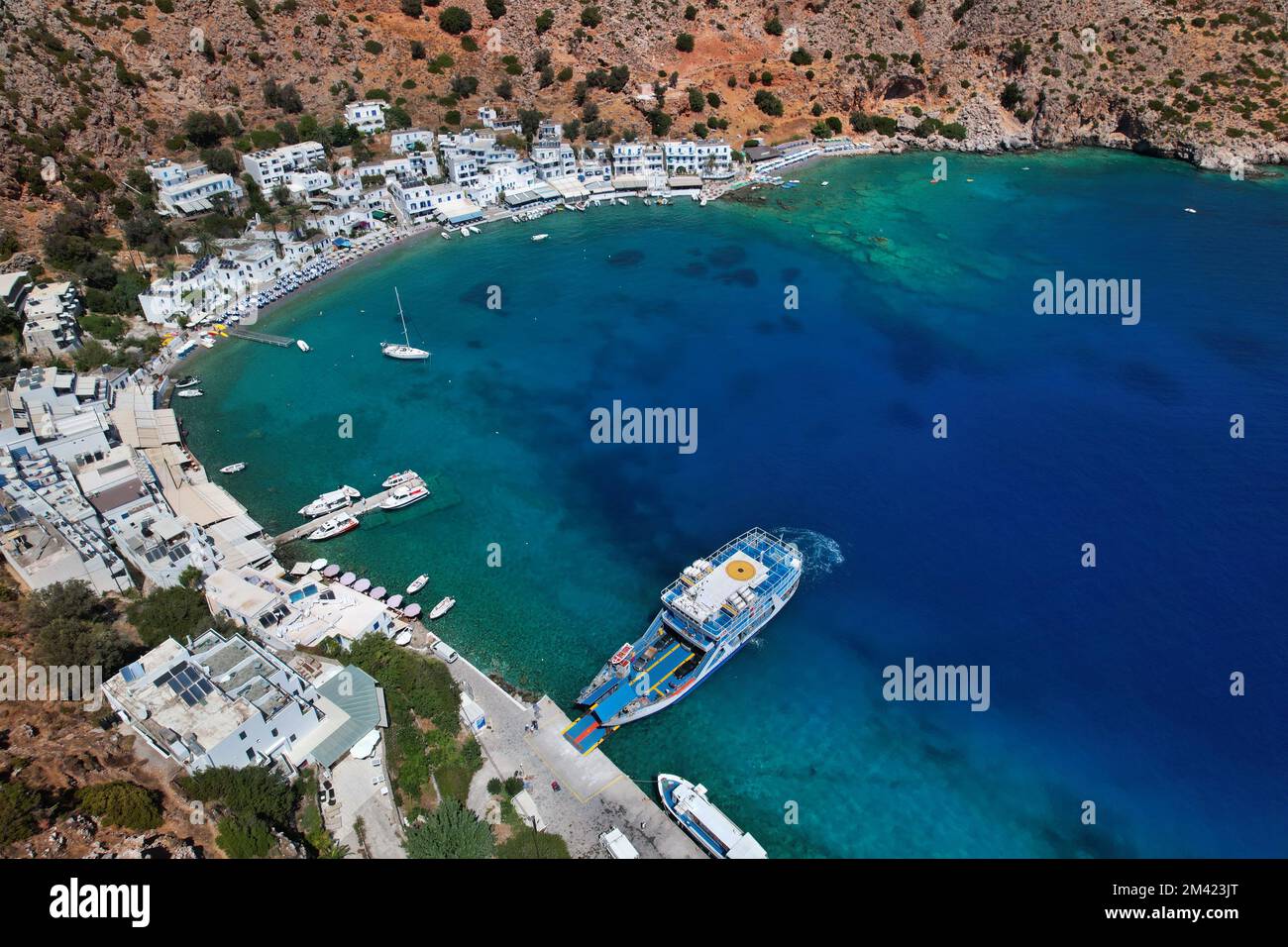 The bird's eye view of the greenish-blue sea with boats and white ...