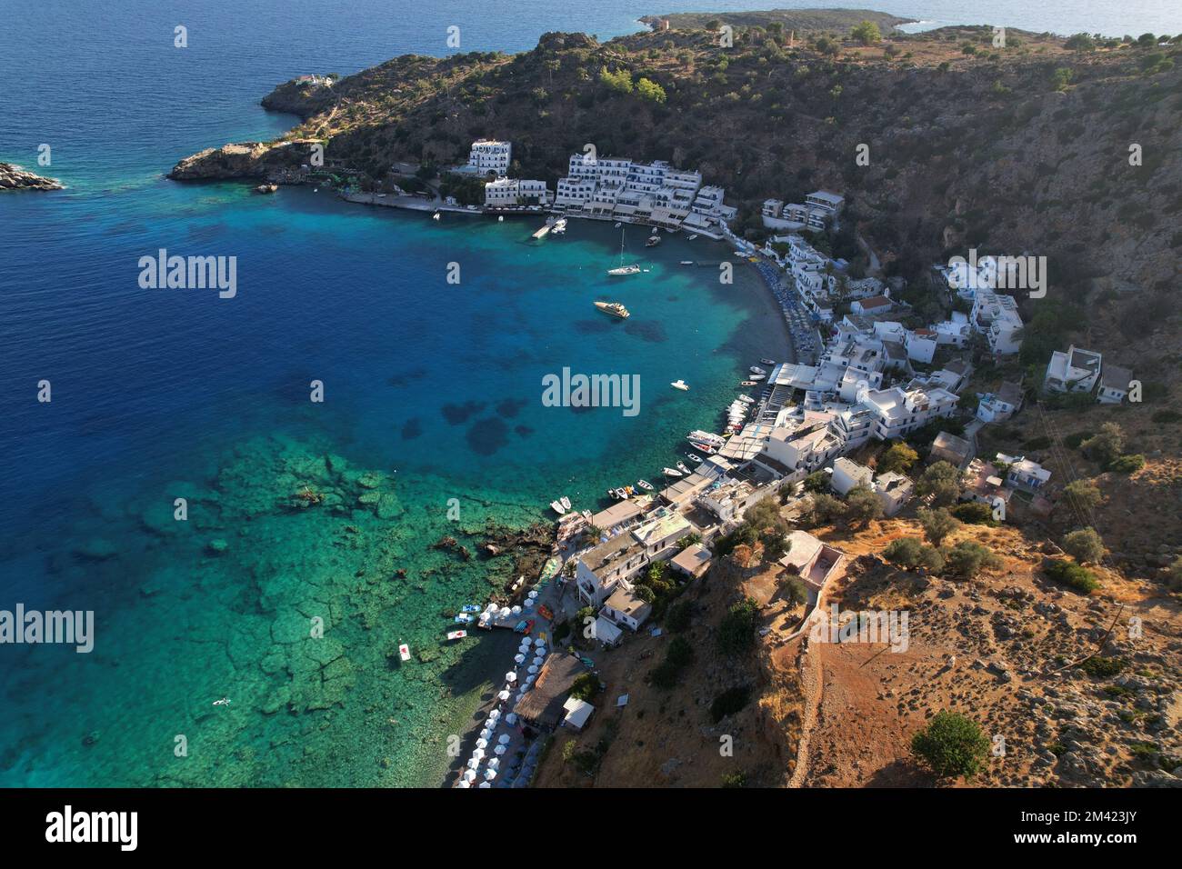 The aerial view of the greenish-blue sea with boats and white buildings ...