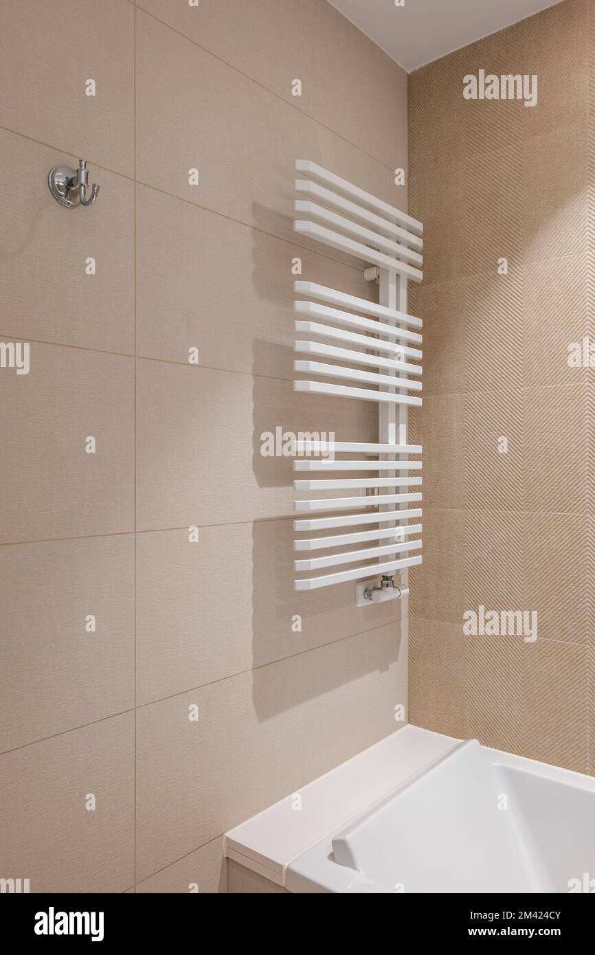Corner of bathroom in the center with a white heating radiator on the ...