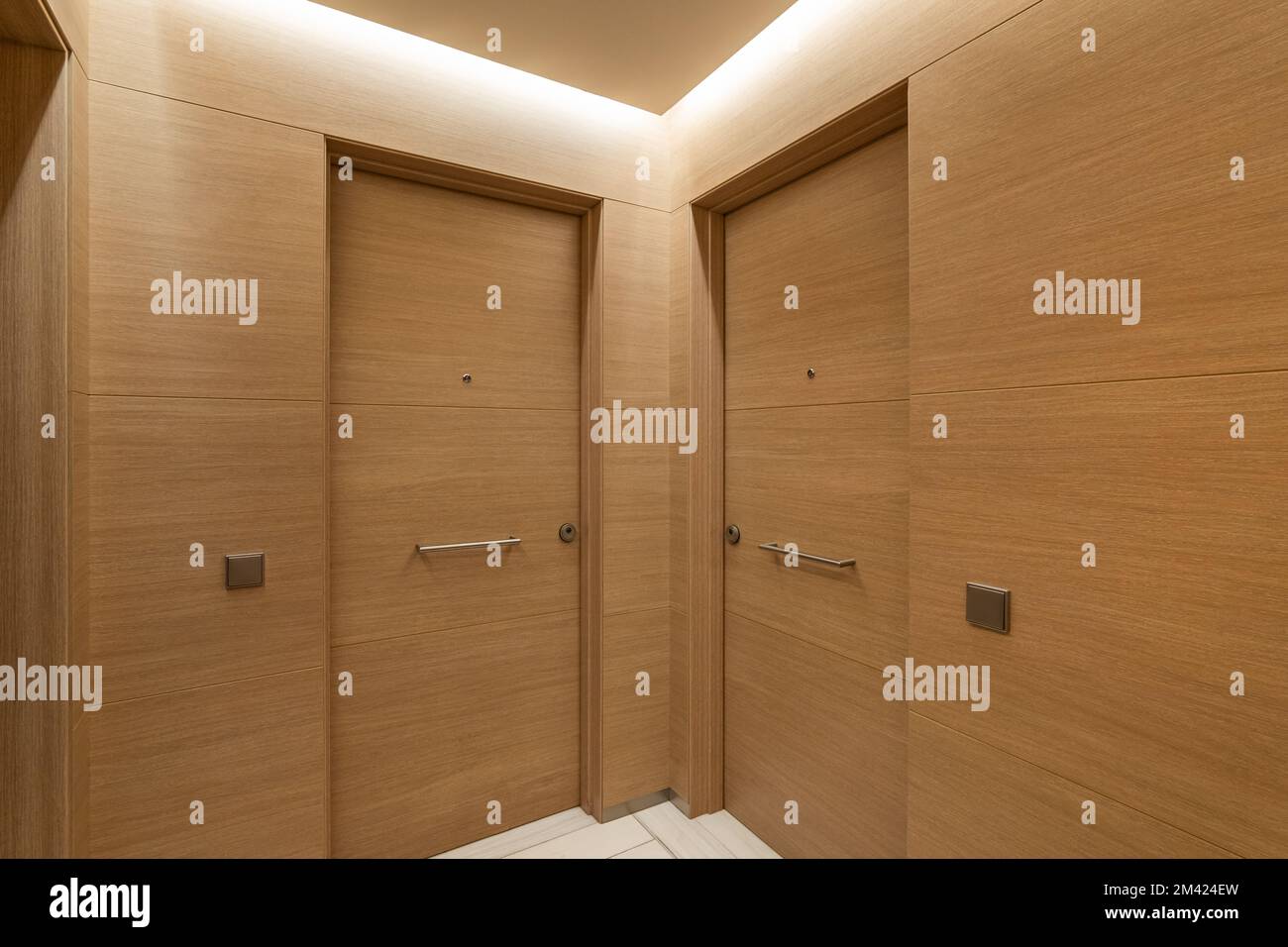 Soft light from niche under ceiling illuminates doors and walls in ...