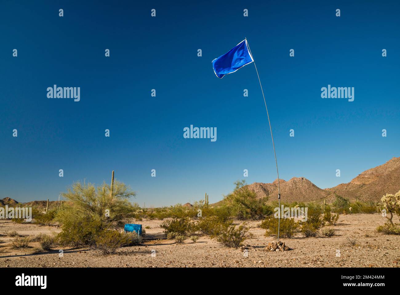Water barrel marked with blue flag, for migrants walking across desert ...