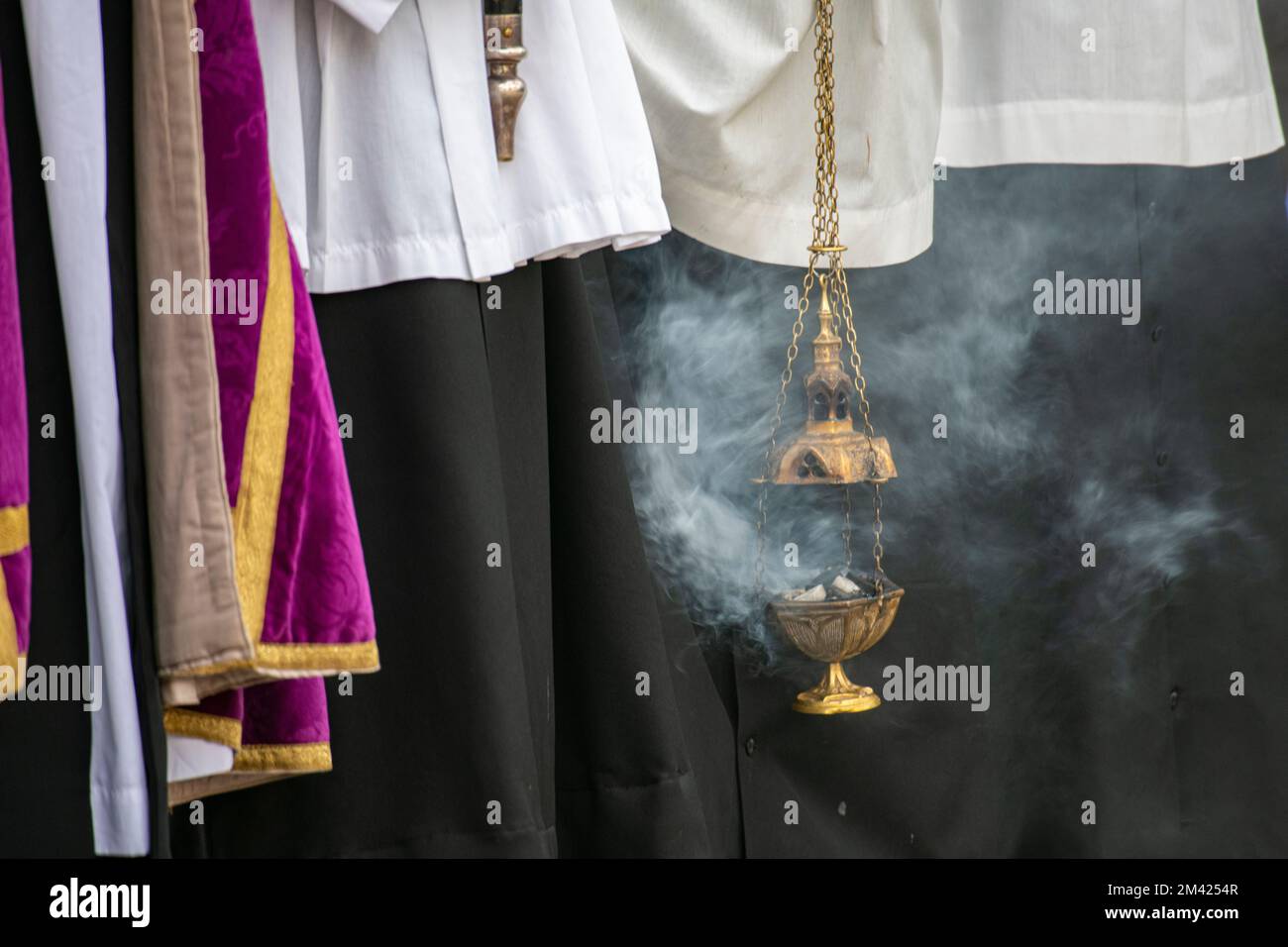 A priest swings a thurible in which incense burns during a Remembrance ...