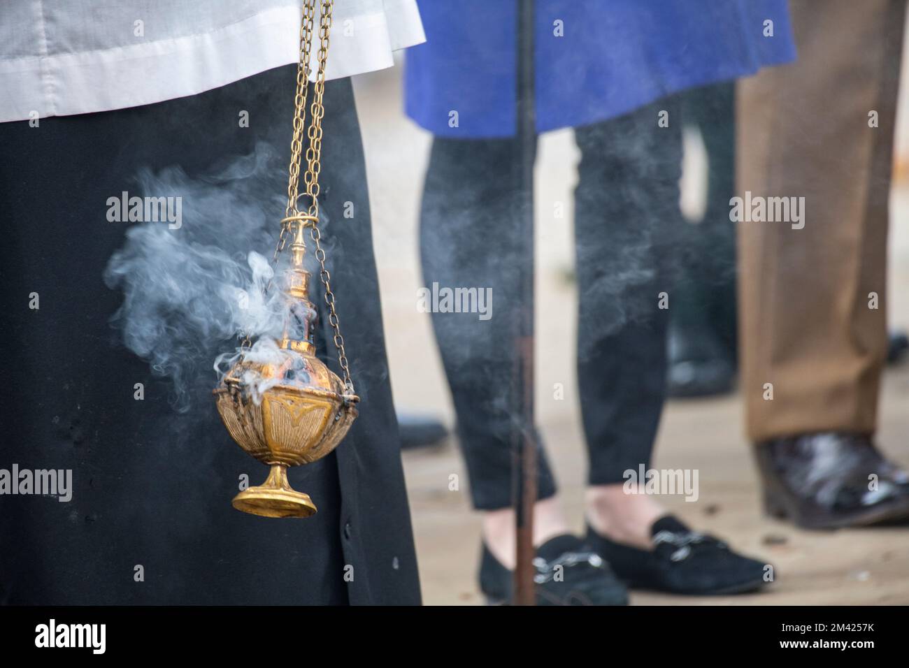 A priest swings a thurible in which incense burns during a Remembrance ...