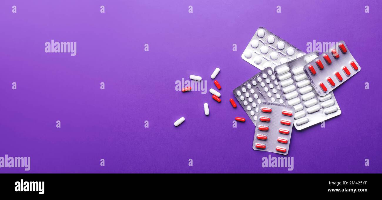 Tablets, pills and red white capsules packed and scattered. Top view ...