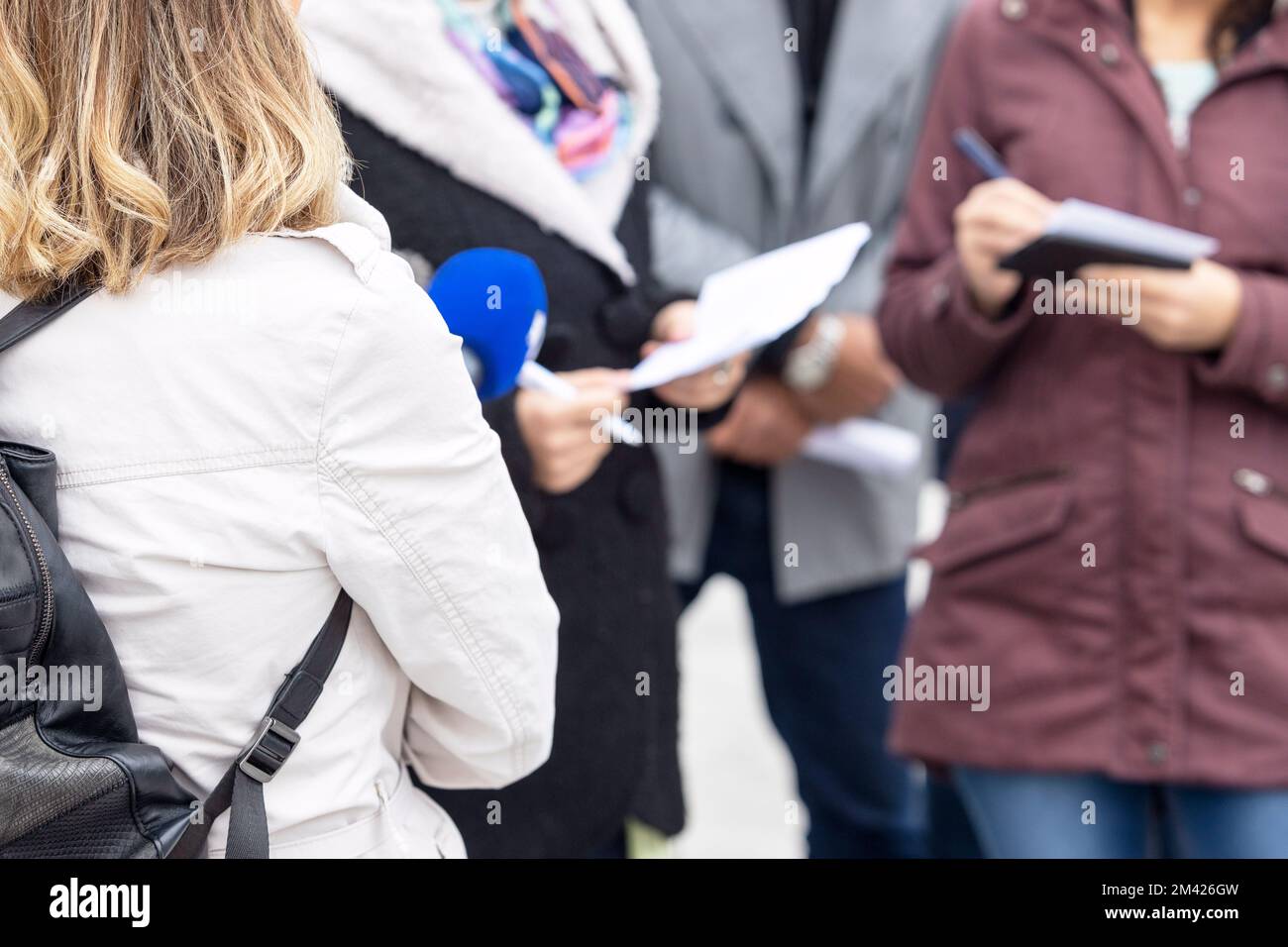 News reporter holding mic, journalist taking notes during media ...
