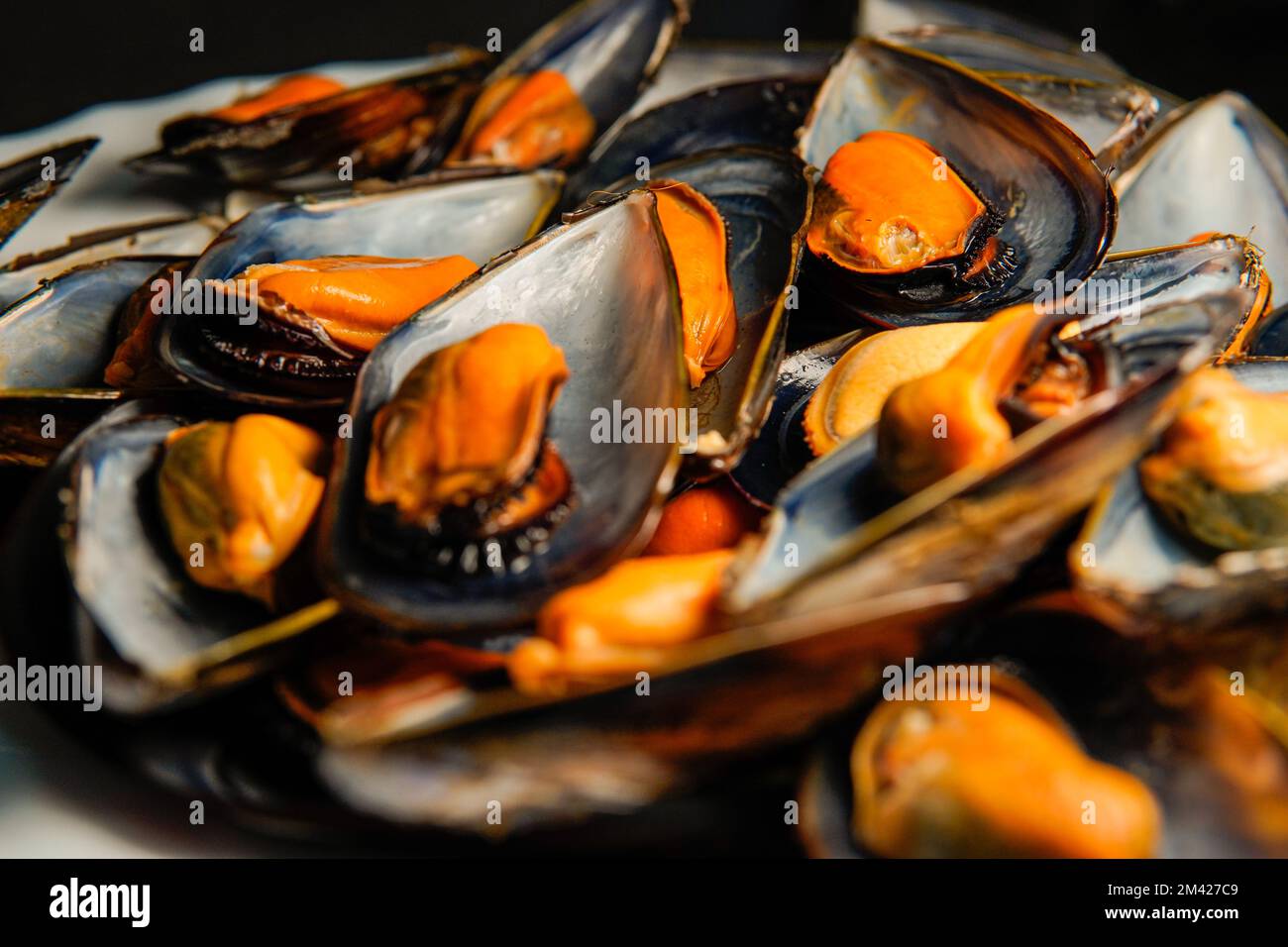 a stack of raw mussels on a plate. Typical Galician and Spanish food ...