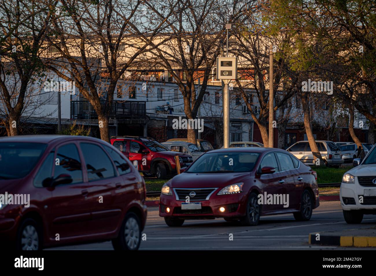 The cars driving on the road in the city with a speed radar on the pole ...
