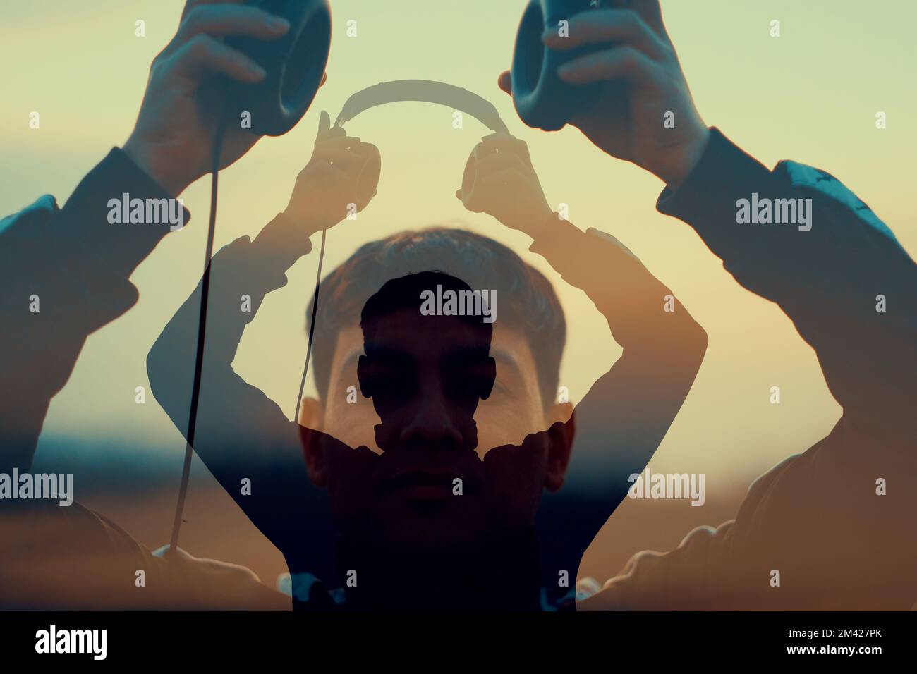 The silhouette of a young man putting on the headphones with his projections at sunset Stock ...