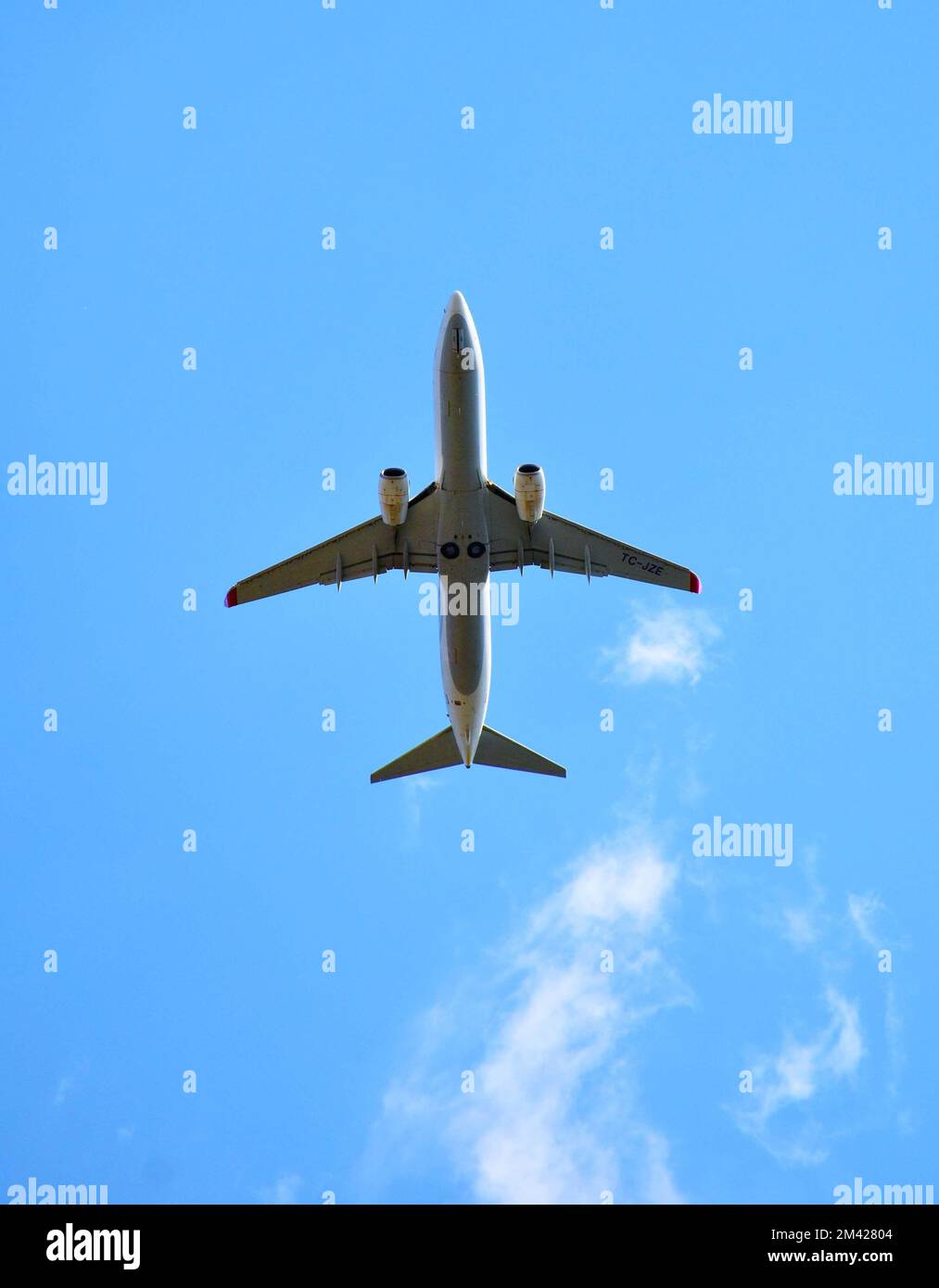 View of the plane in flight from the ground. Blue clear sky with ...