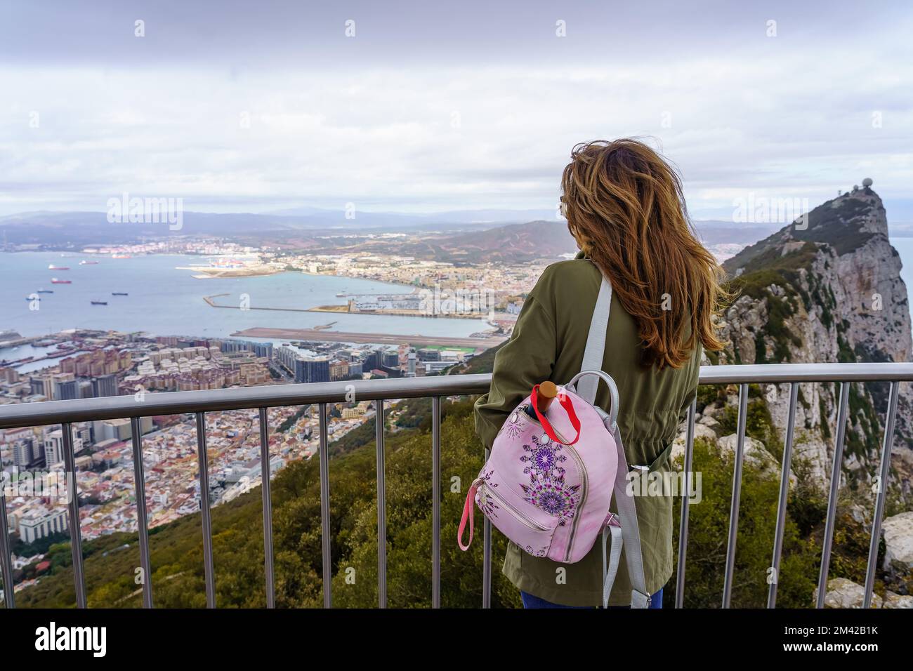 Woman with her back on top of the rock of Gibraltar contemplating the ...