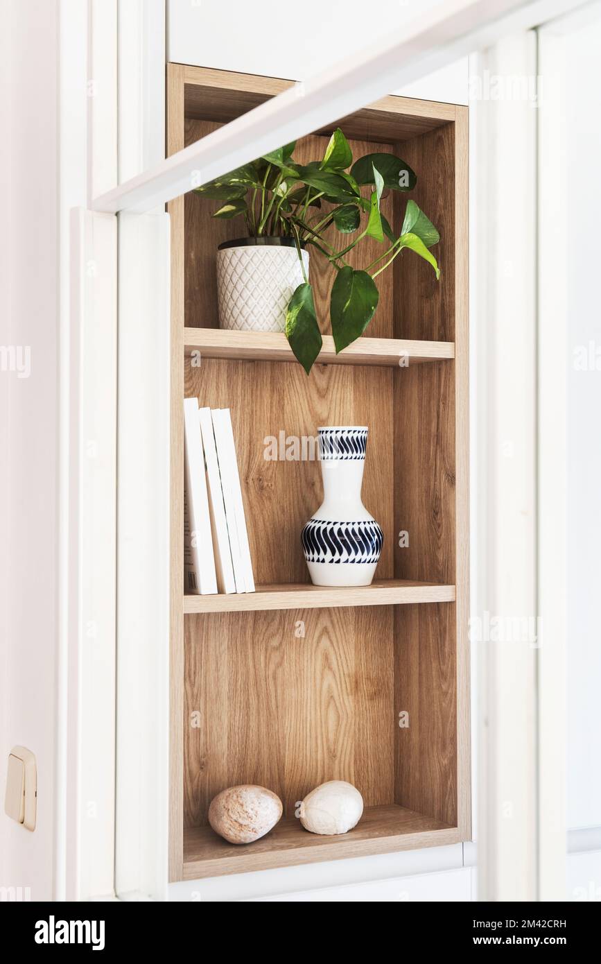 A small oak shelf integrated into a niche in a wall with decorative ...