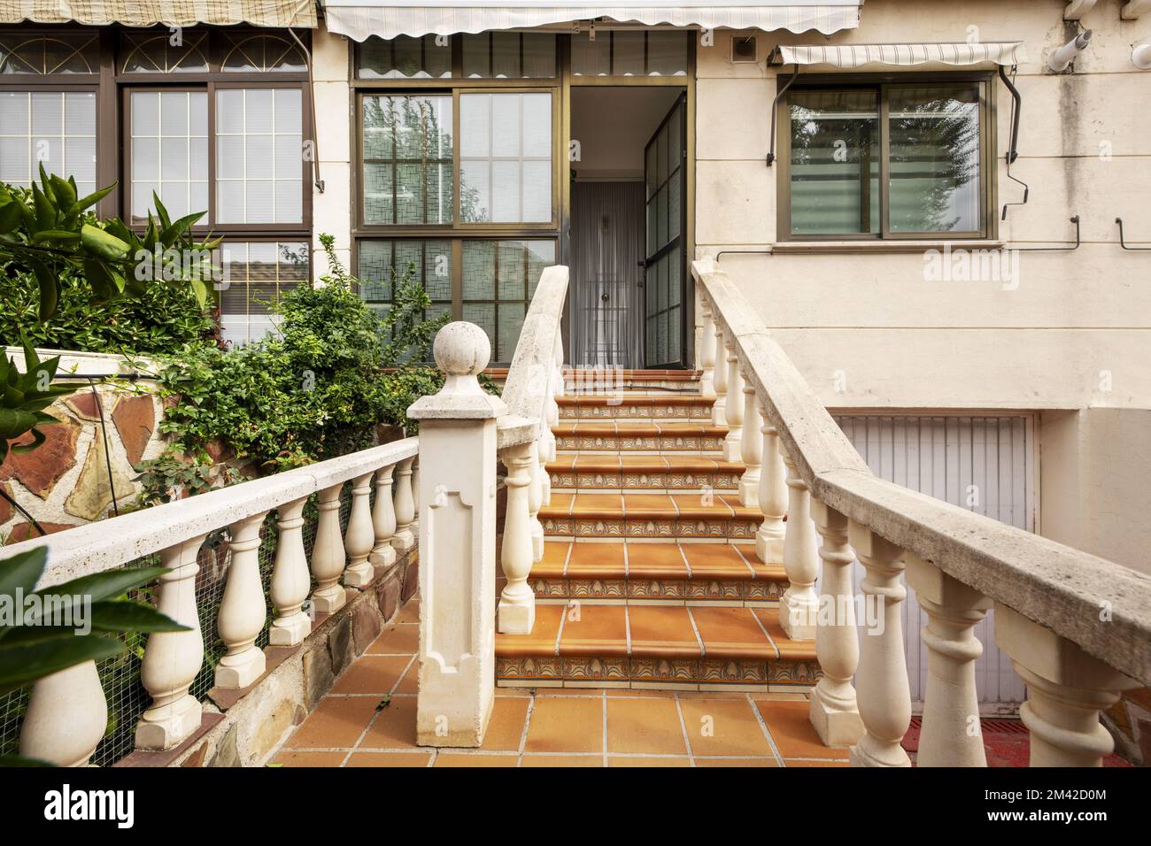 Stairs on the entrance porch of a detached house with white concrete ...