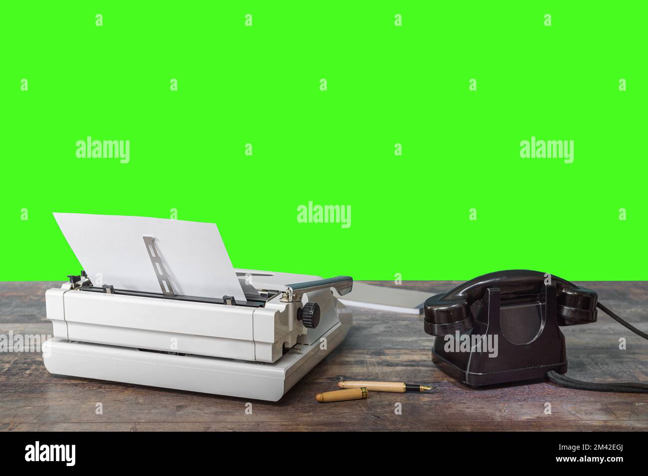 Typewriter, old telephone, ink pen and notepad on a textured table ...