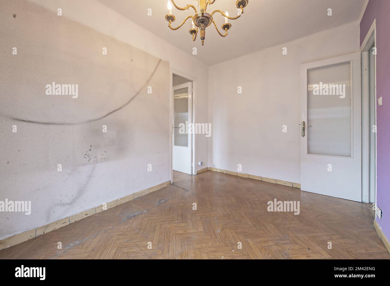 Empty room with dirty walls with white and glass doors to other rooms ...