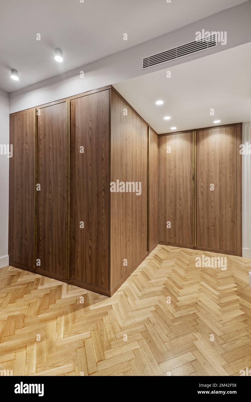 Wardrobe with root wood doors with full-length handles in the room with ...