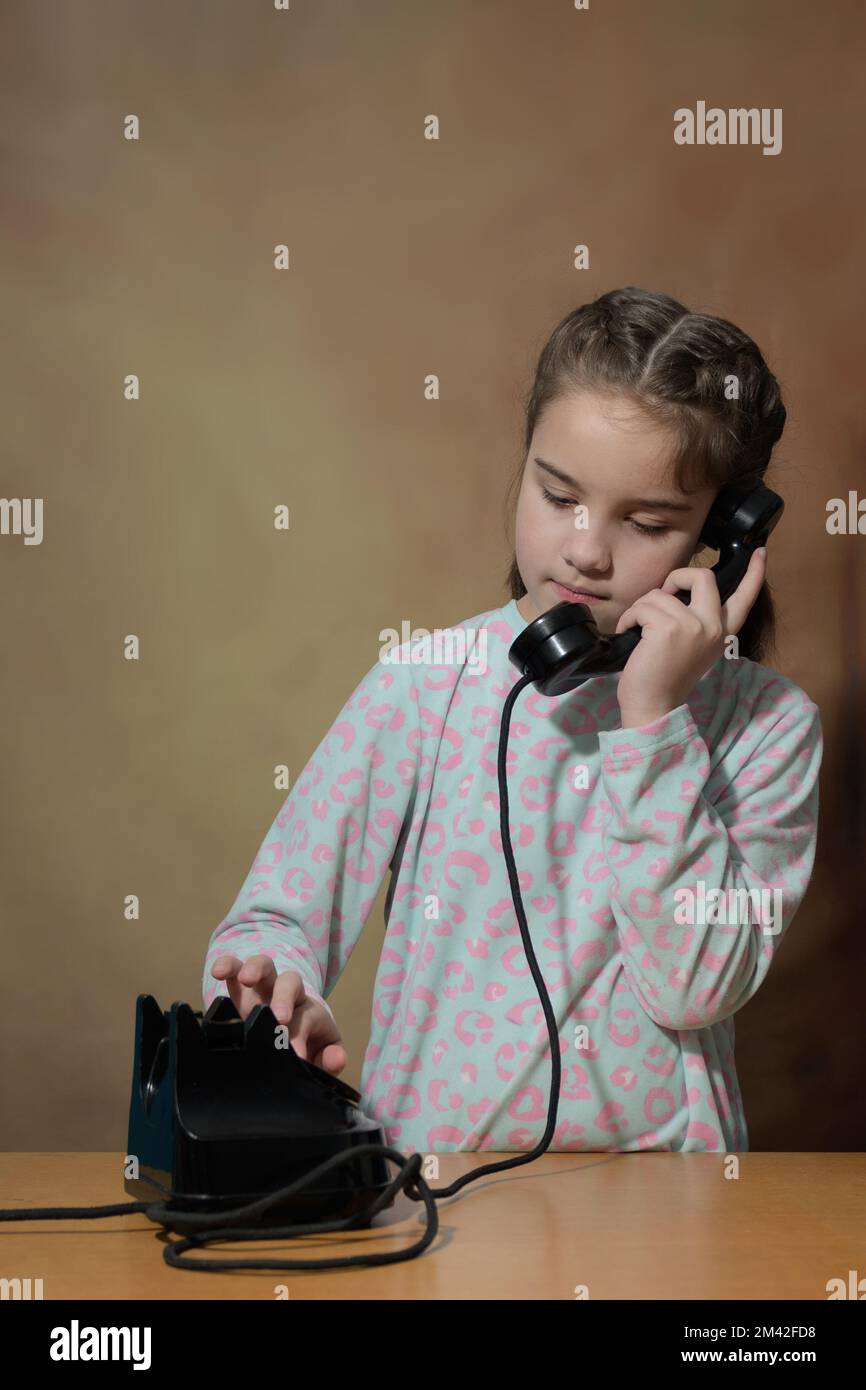 Portrait of a girl with a telephone. The teenage girl dials a number on ...