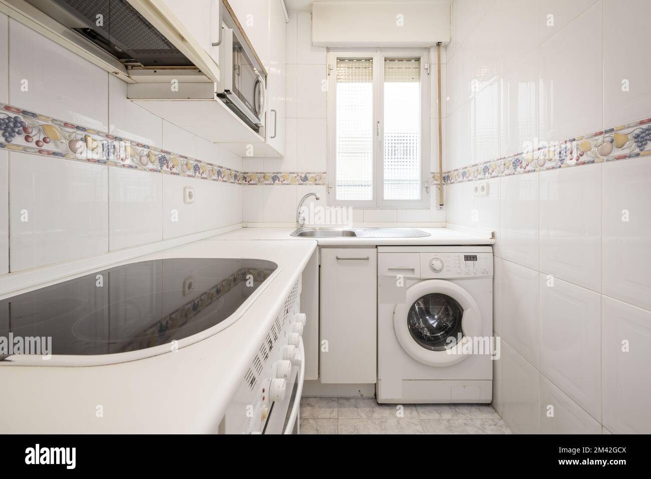 Kitchen with white furniture with counter and appliances of the same ...