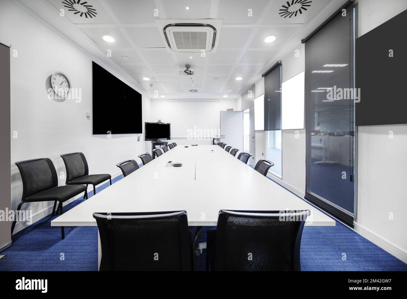 Boardroom office with a long table with black chairs and graphics ...