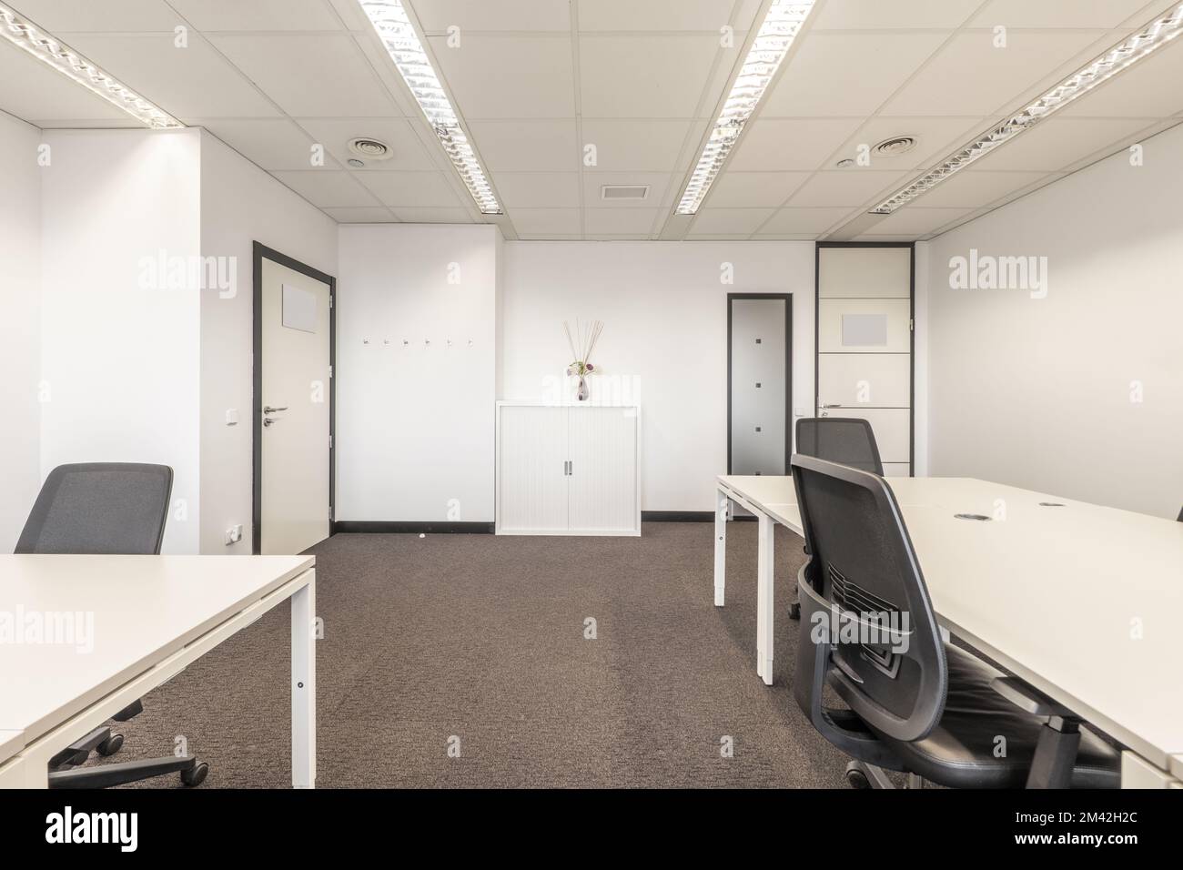 Coworking office, with several work tables and swivel chairs, gray ...