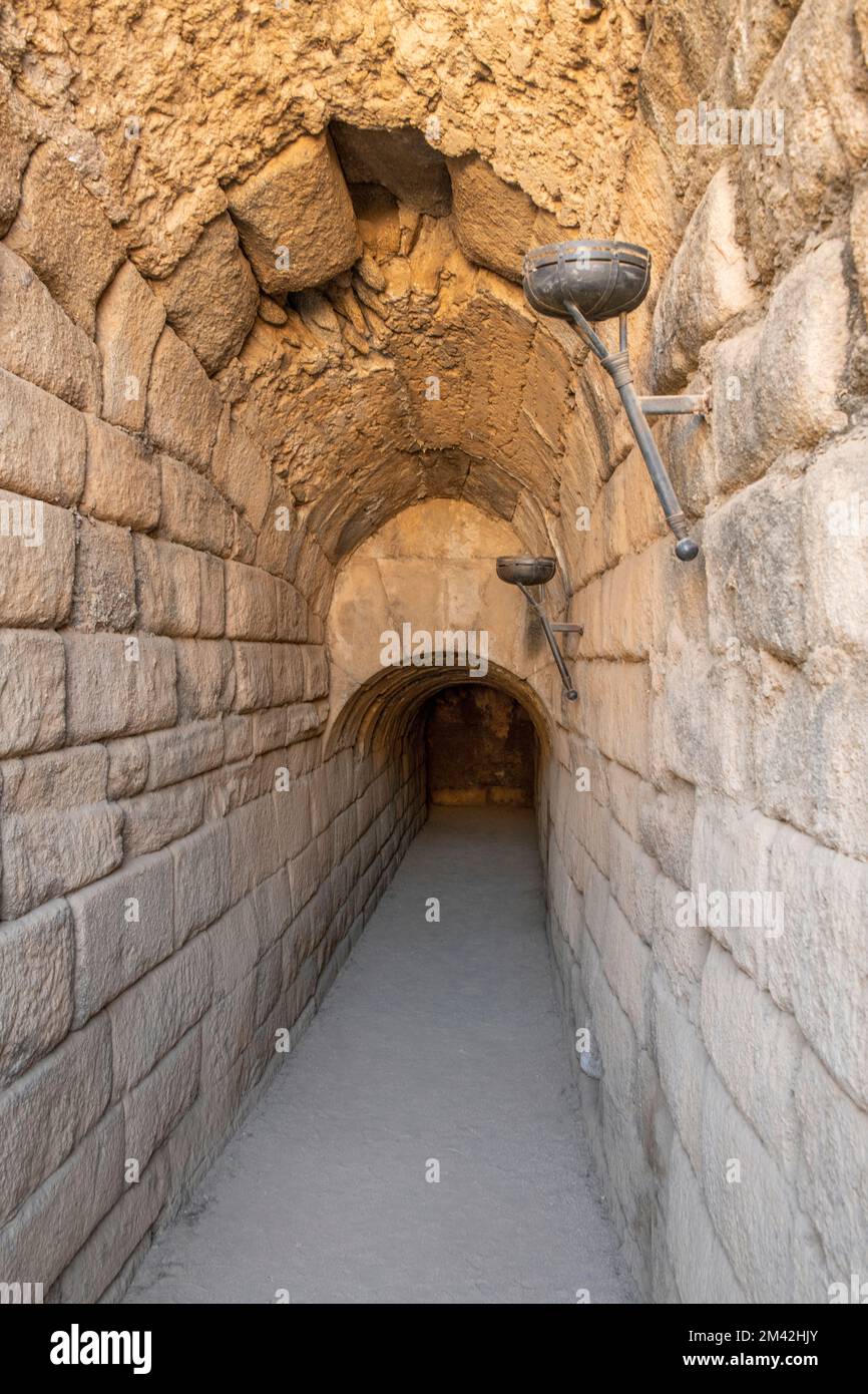 Stone passageway with metal cauldrons on the walls of an ancient Roman ...