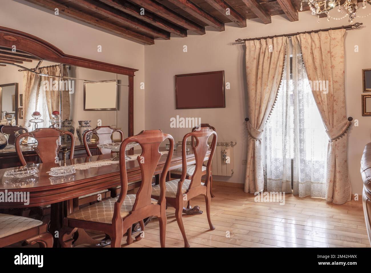 Living room with long wooden table with matching chairs, sideboard with ...