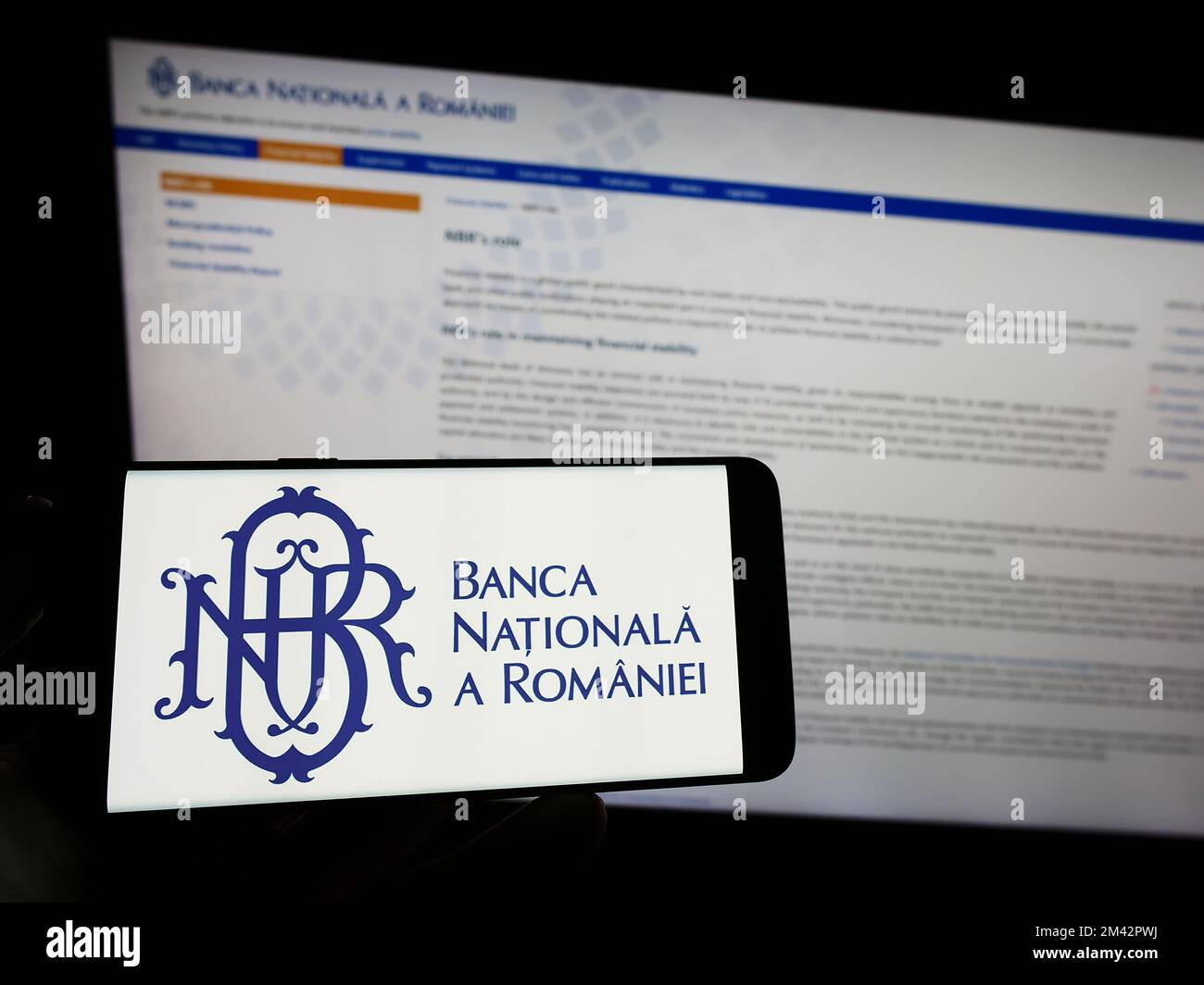 Person holding smartphone with logo of central bank Banca Nationala a ...