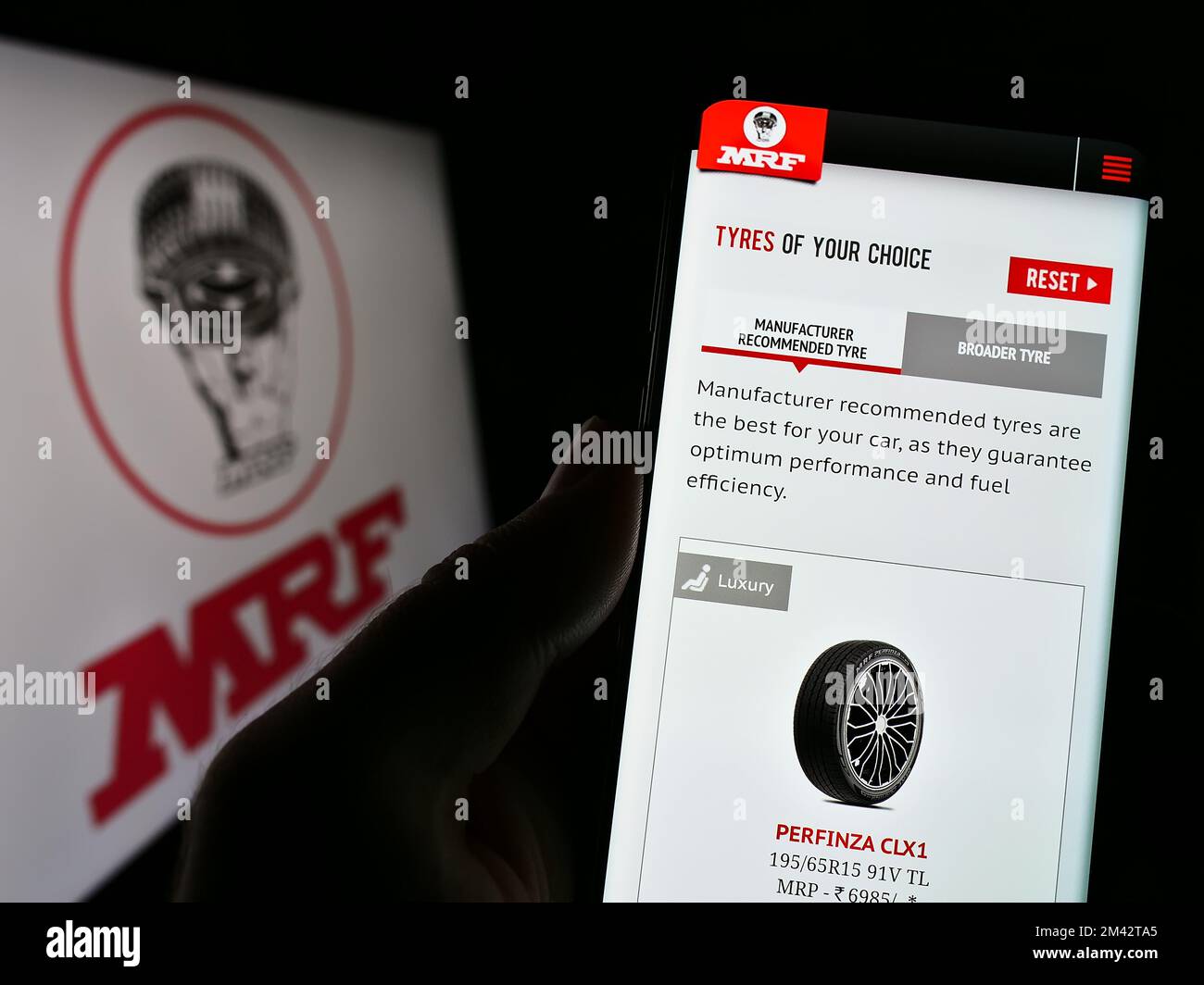 Person holding cellphone with website of Indian company Madras Rubber ...