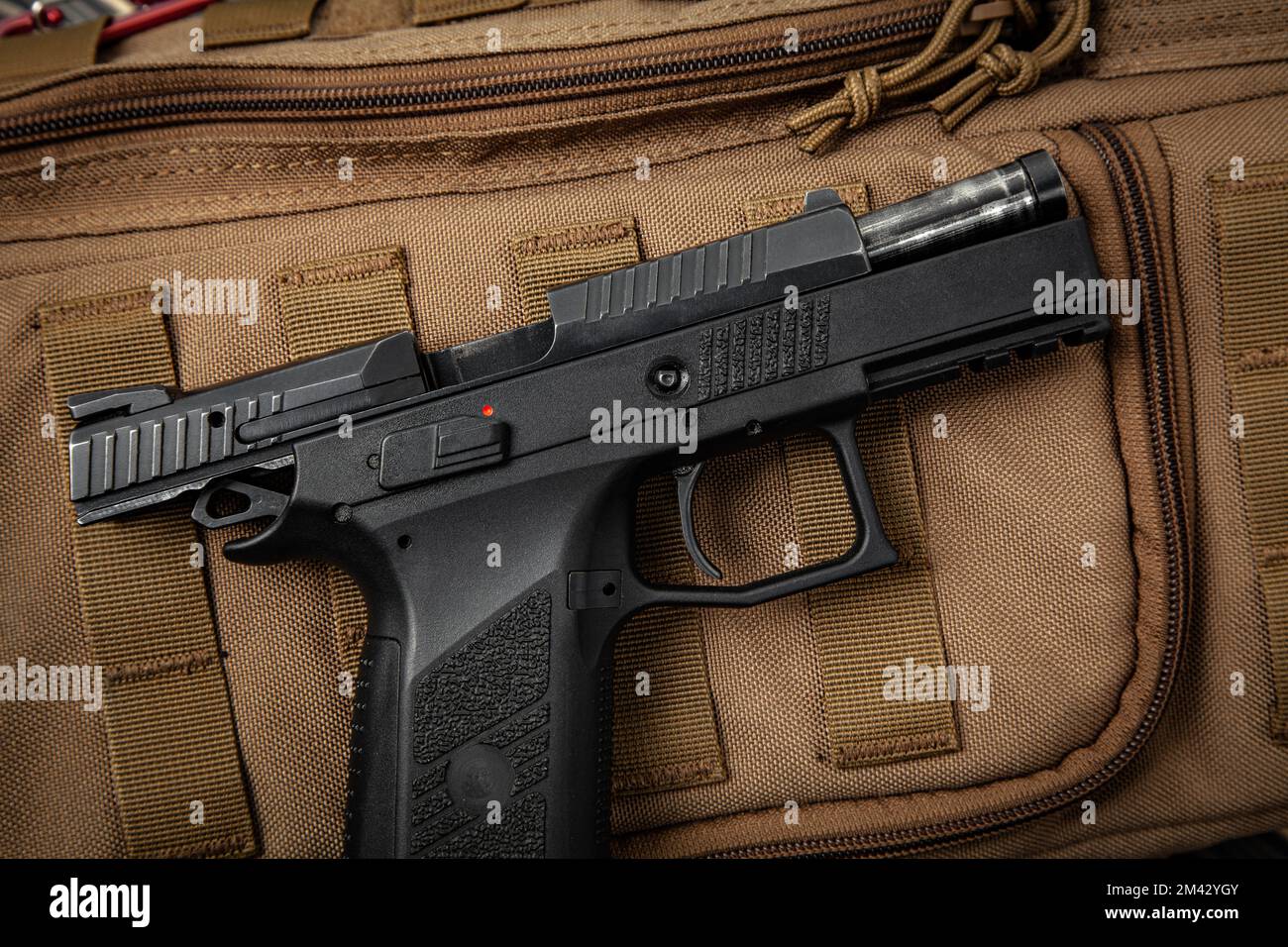 A modern black pistol on a brown backpack. Weapons for sport and self ...