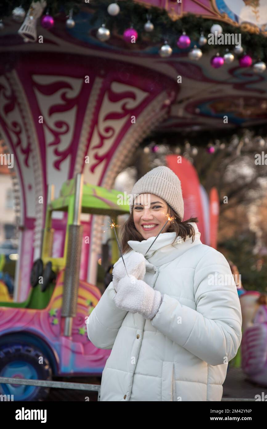 fair . attractions , carousel . girl dressed in a white jacket and a ...