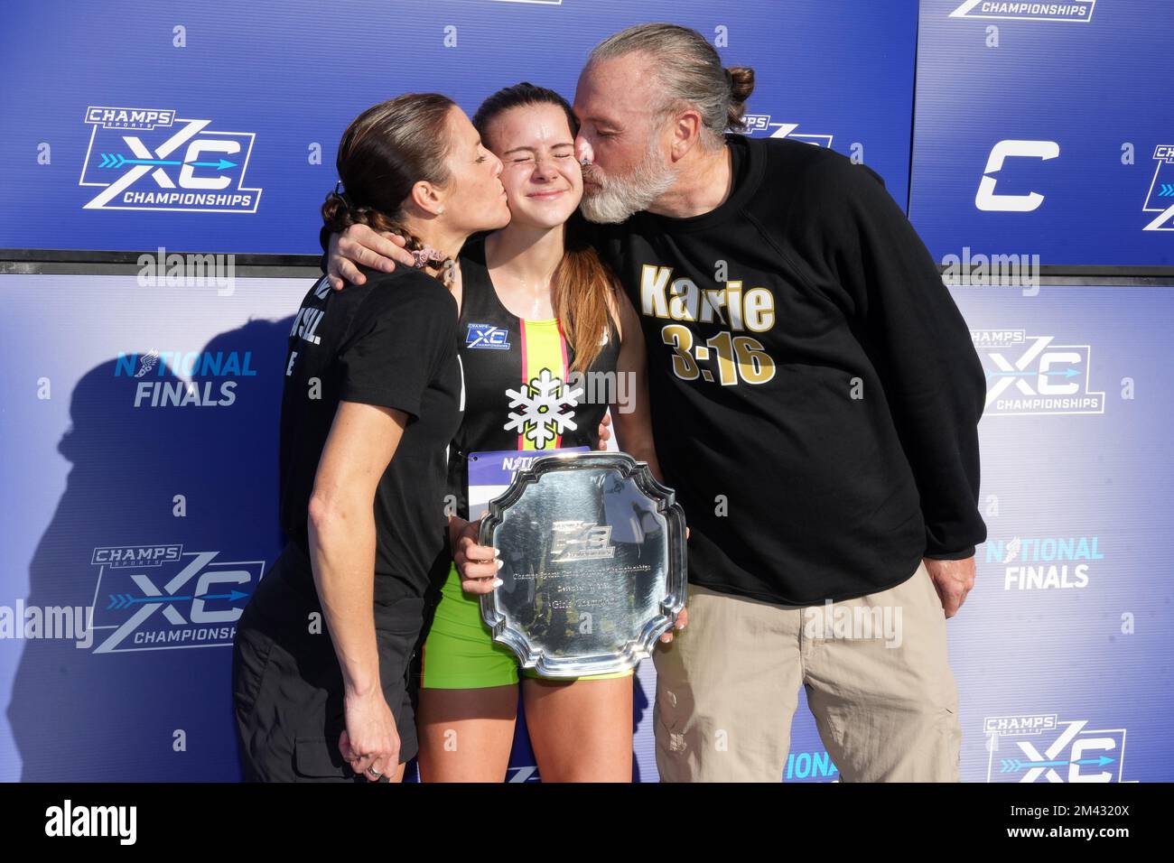 Karrie Baloga (center) is kissed by her parents, mother Katie Baloga ...