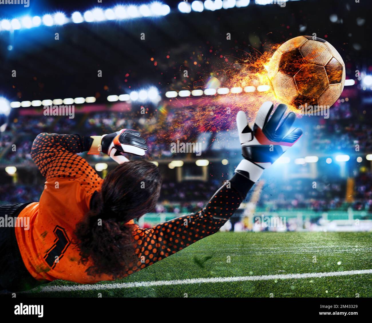 Goalkeeper catches the fireball in the stadium during a football game ...