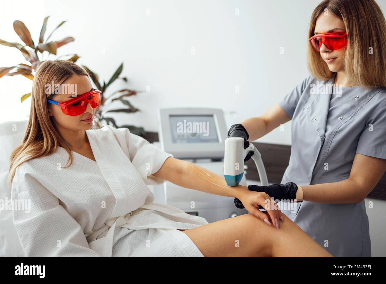 Young woman receiving photo epilation while visiting beauty center on ...