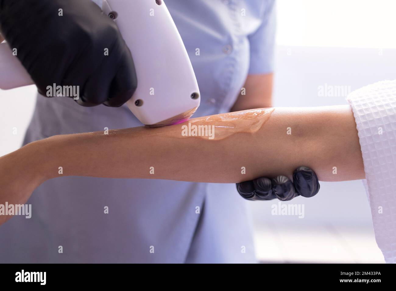 Young woman receiving photo epilation while visiting beauty center on ...