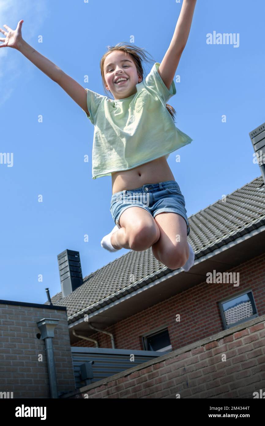 Happy summer. Girl jump on a trampoline Stock Photo - Alamy