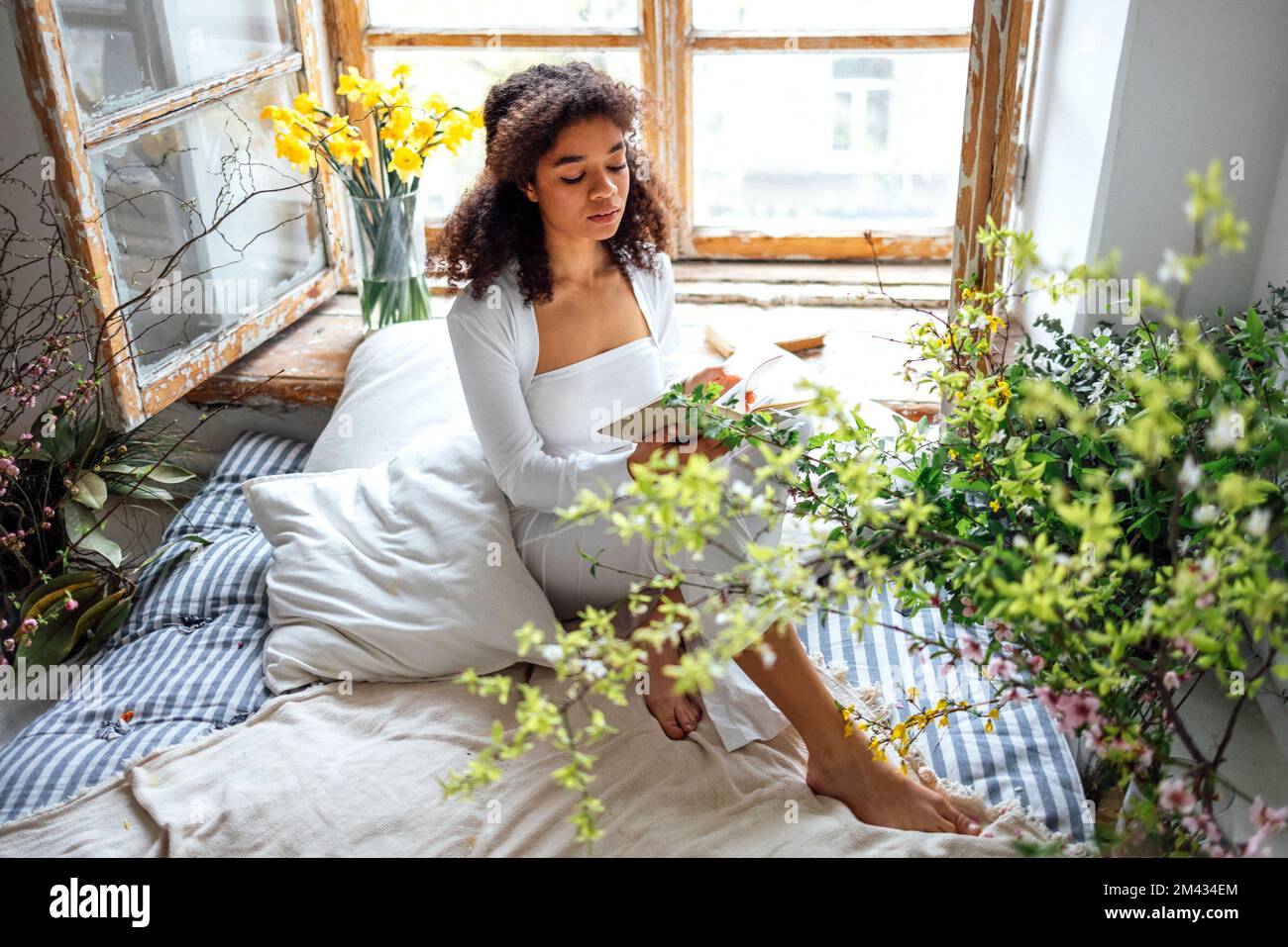 Pretty romantic african american girl, reading book sitting on ...