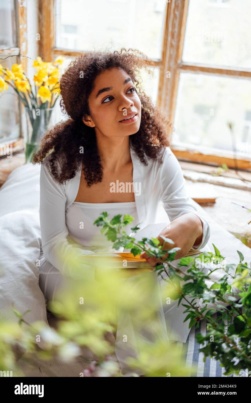 Pretty romantic african american girl, reading book sitting on ...