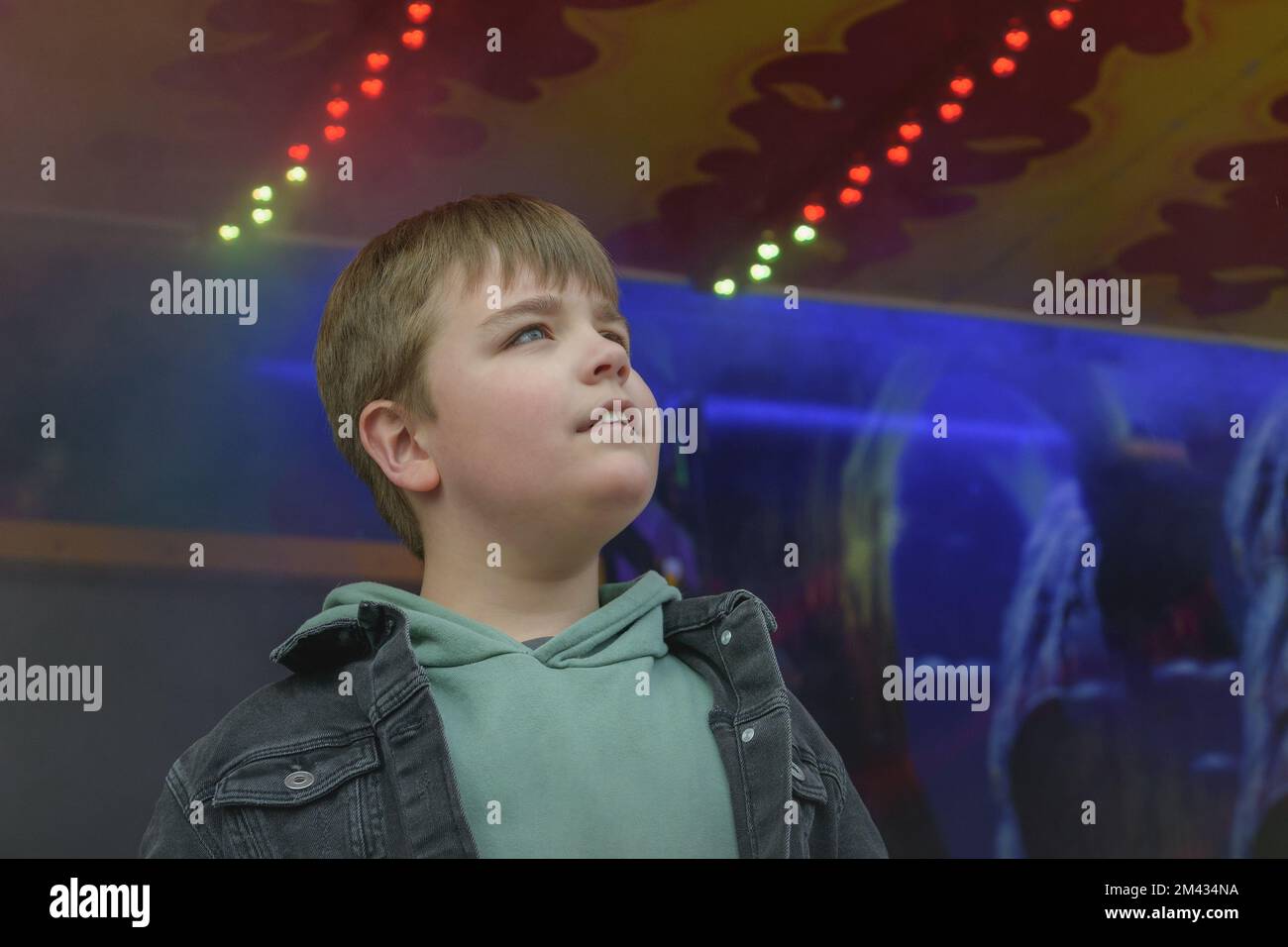 Portret. Boy looking on attraction in the amusement park Stock Photo ...