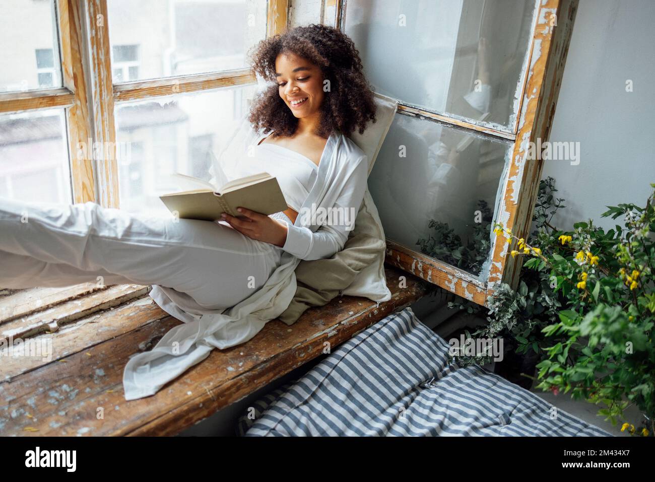 Pretty romantic african american girl, reading book sitting on ...