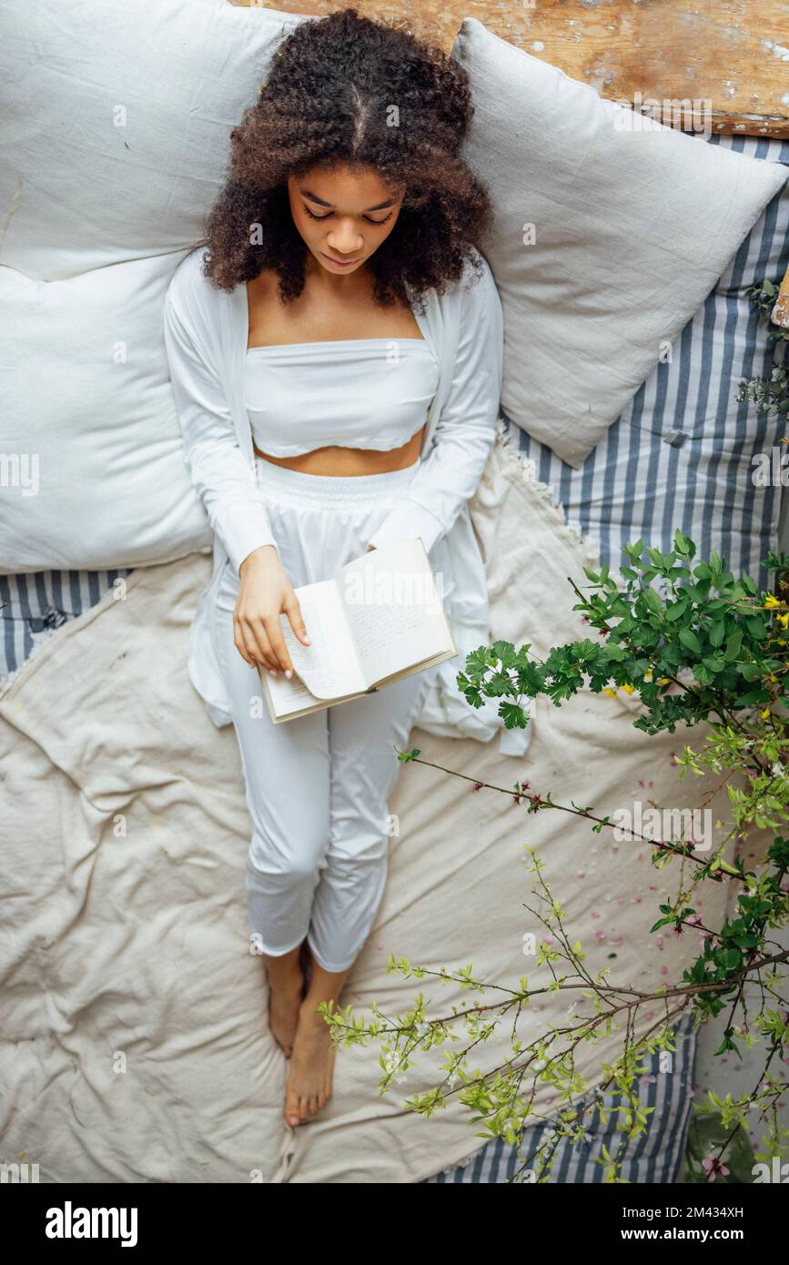 Pretty romantic african american girl, reading book sitting on ...